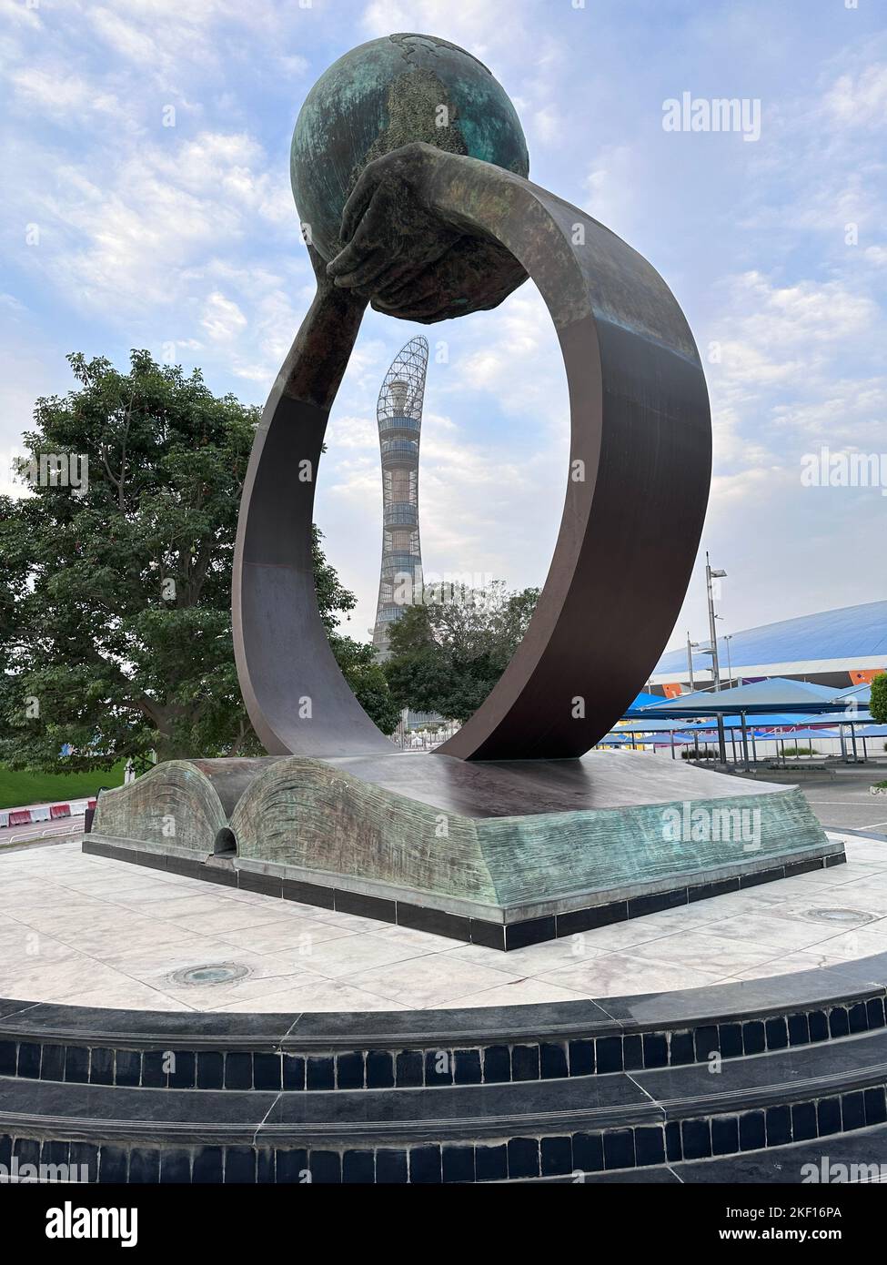 Hands rising from a book support the globe in this sculpture at Qatar's ...