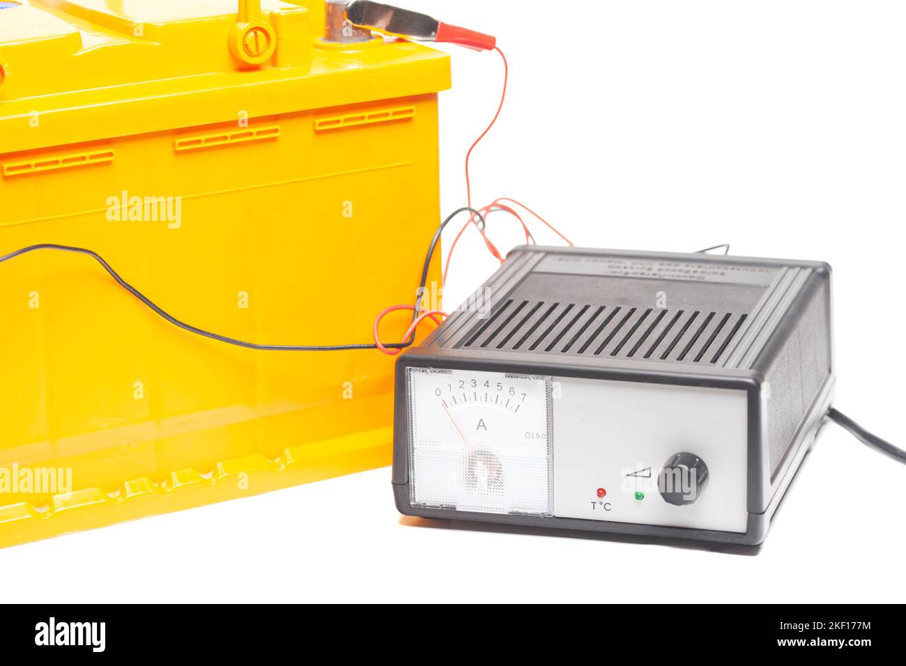 yellow car battery with car battery charger isolated on white ...