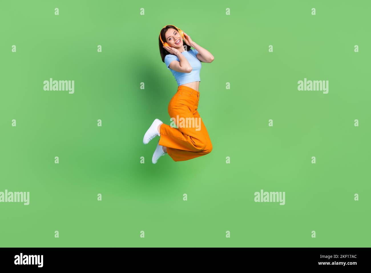 Full body photo of crazy adorable lady jumping hands touch headphones ...