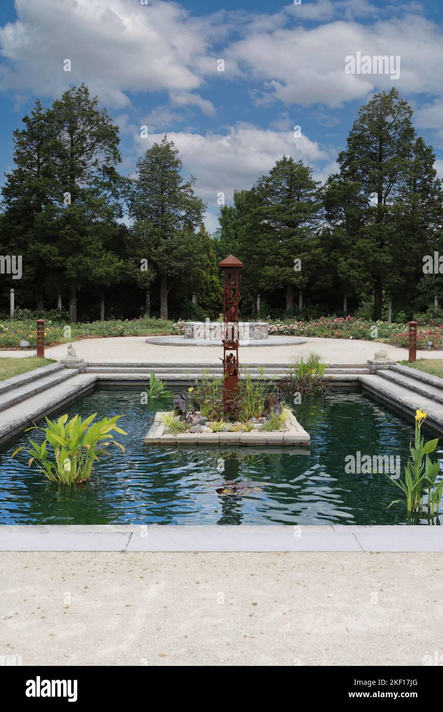 A man made pond with water plants and a sculpture at Boerner Botanical ...