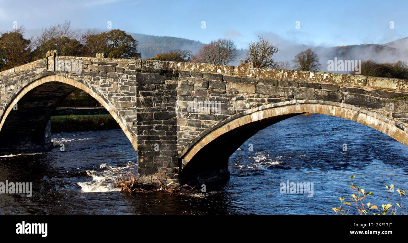 Autumn mists above Pont Fawr Bridge a three arched stone bridge over ...