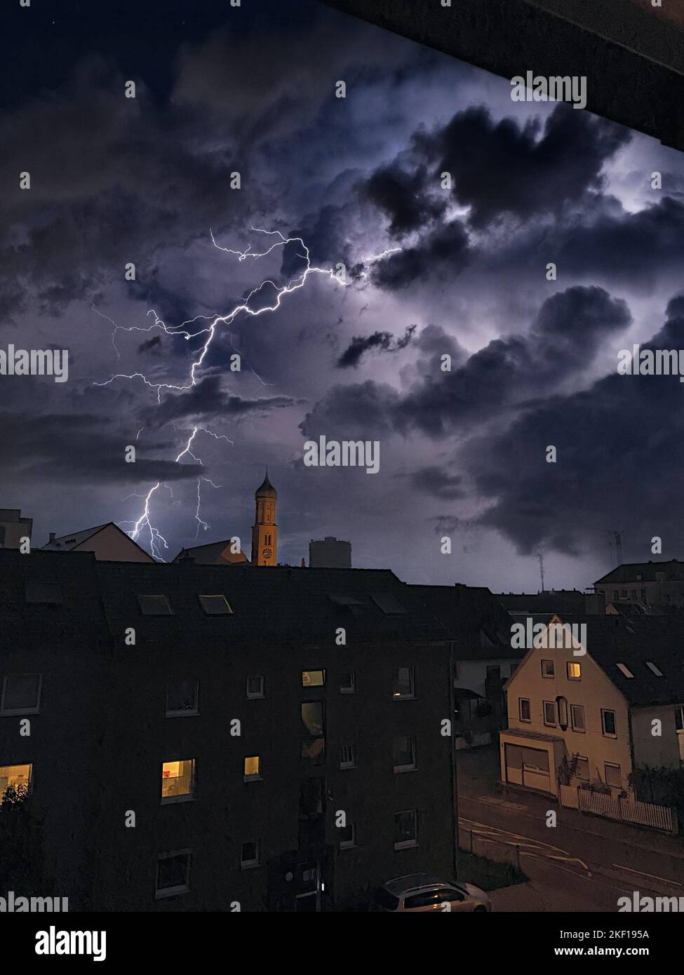 A vertical shot of a striking lightning in the stormy night sky over ...