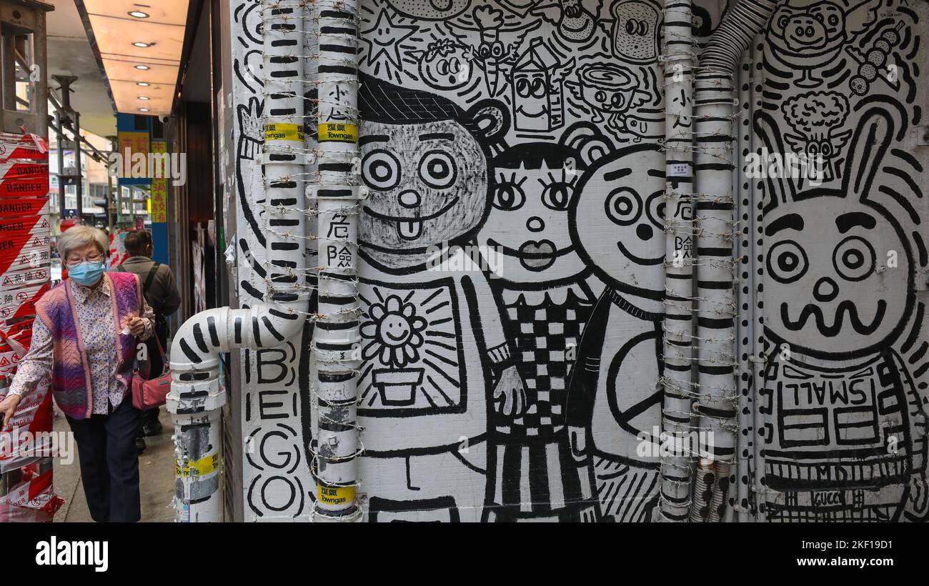 A woman passes a cartoon mural in Wan Chai. 08NOV22 SCMP / Xiaomei Chen ...