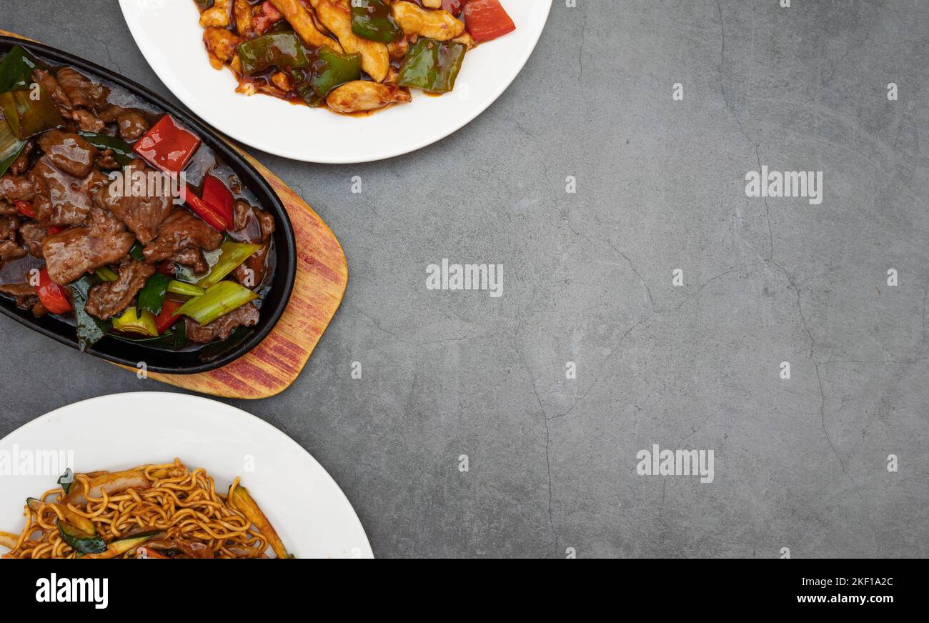 Variety of oriental dishes on a rustic background with space for text ...