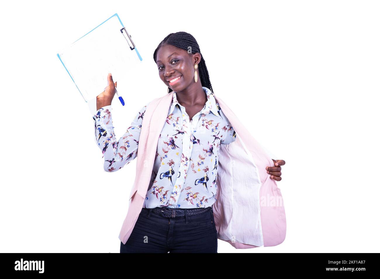 portrait of a beautiful young student holding a pen and clipboard while ...