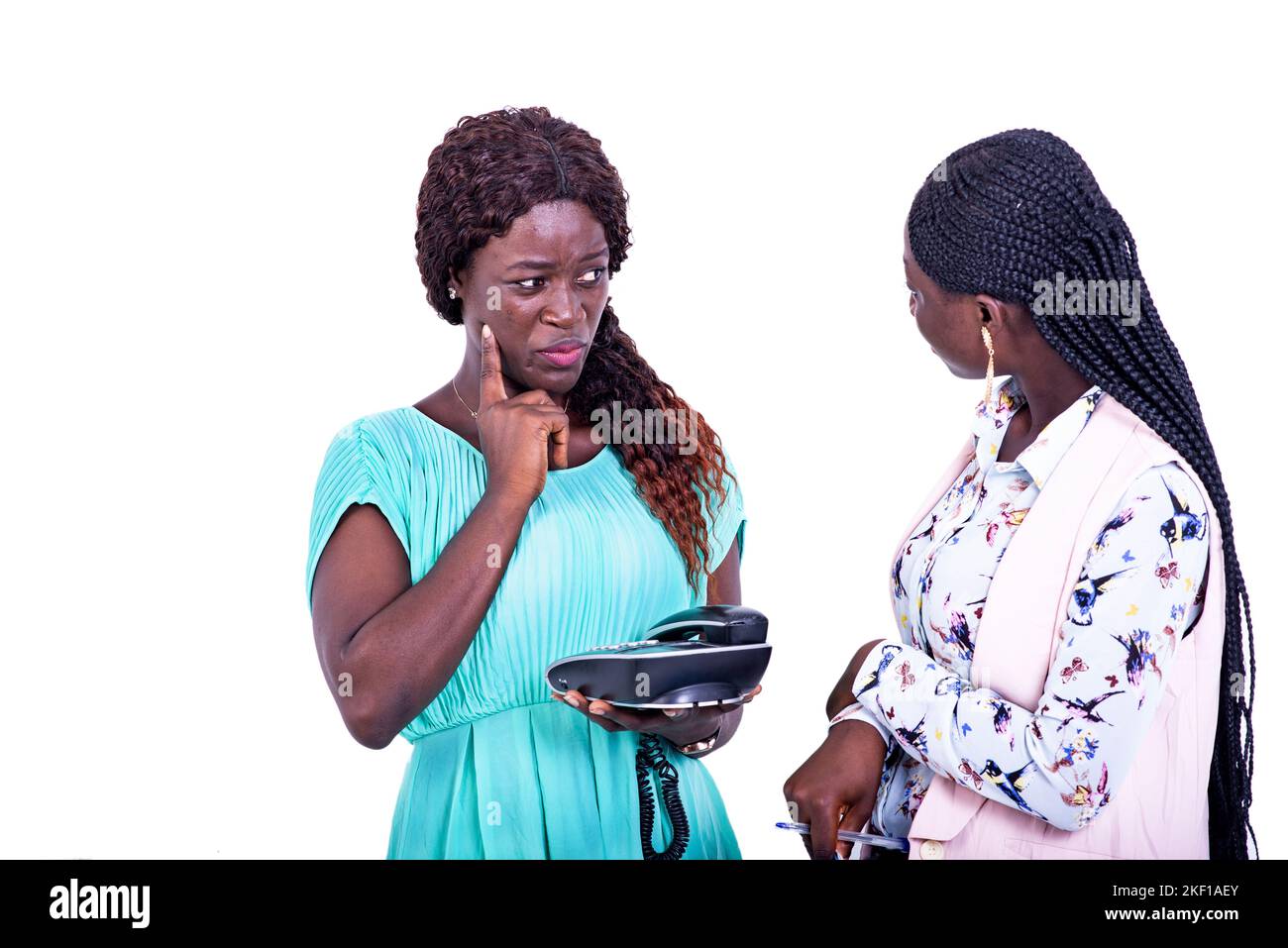 portrait of two beautiful young women chatting together while smiling ...