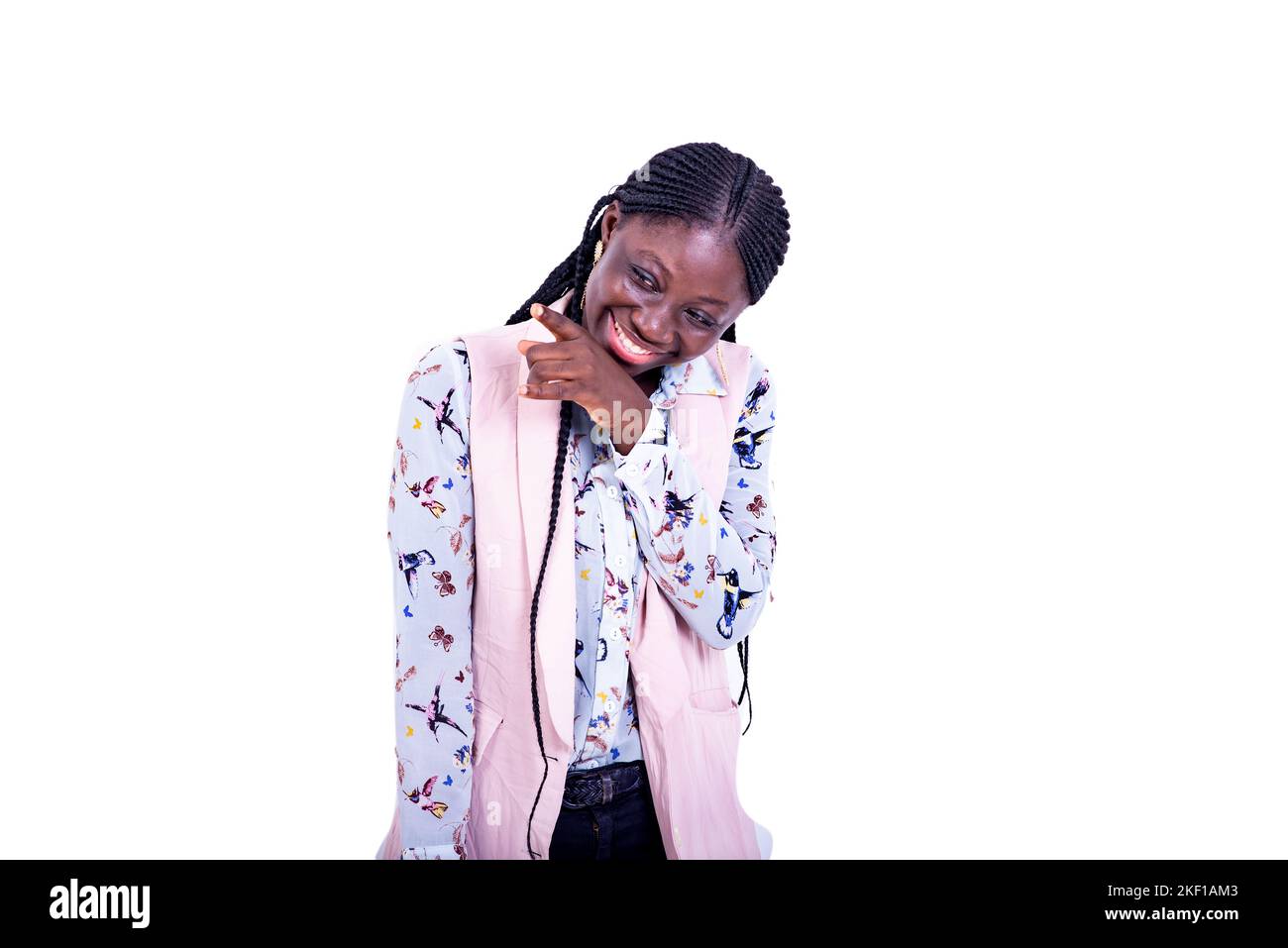 a young woman standing on a white background pointing the finger at ...