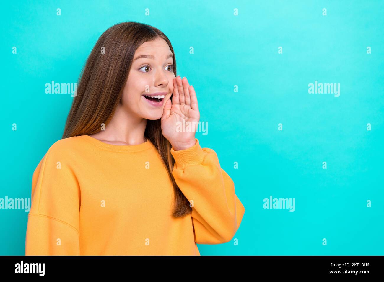 Profile photo of excited teen girl wear orange sweatshirt touch cheeks ...