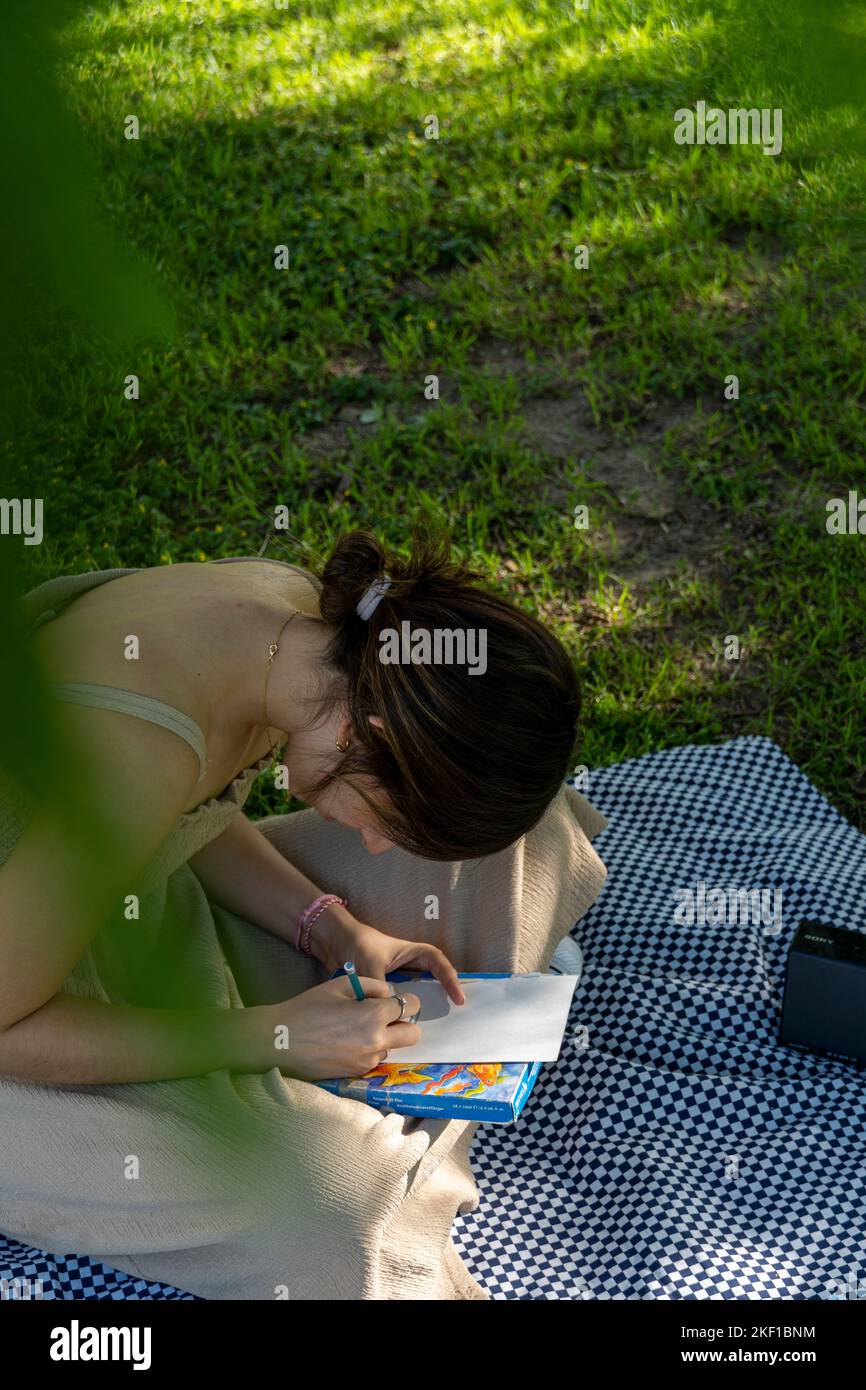 Young beautiful woman drawing a painting outdoors, talented artist with ...