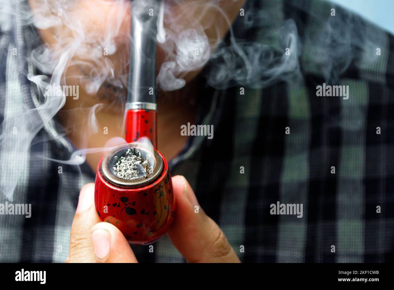 A closeup shot of a man's hand with a smoking pipe Stock Photo - Alamy
