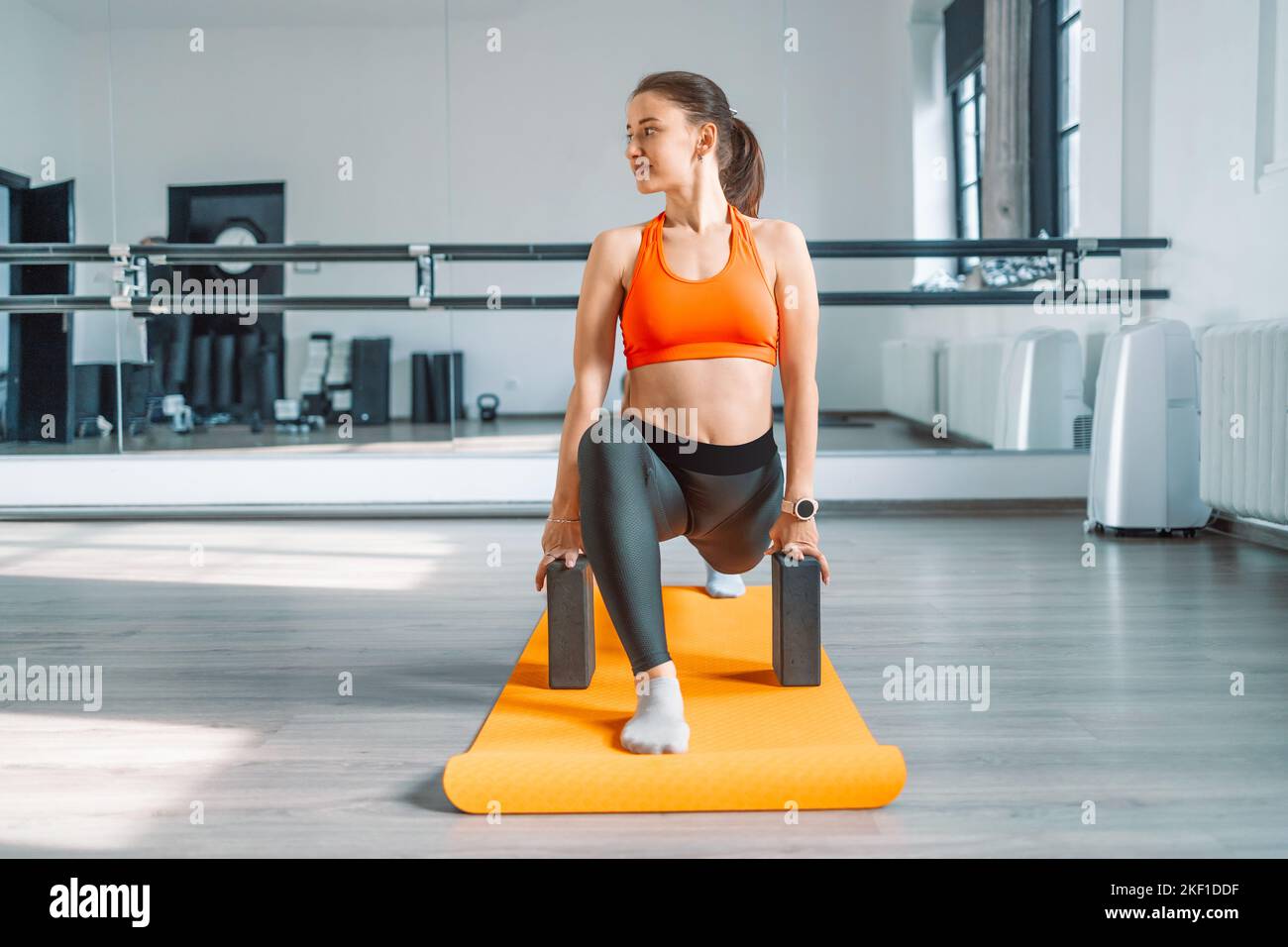 Yoga Stretch. Fool body portrait of a cheerful athletic woman in orange ...