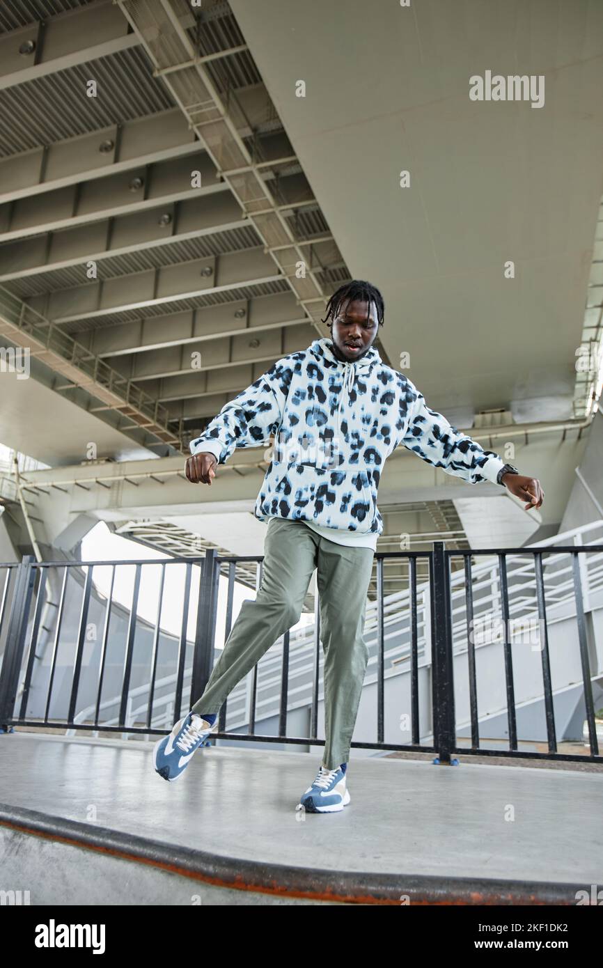 Vertical full length portrait of young black man dancing outdoors in ...