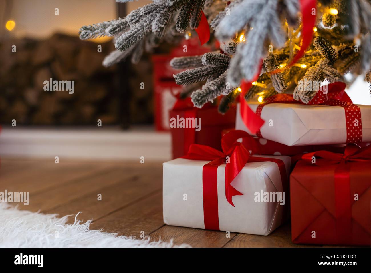 Beautiful Christmas gift boxes on floor near fir tree in room Stock ...