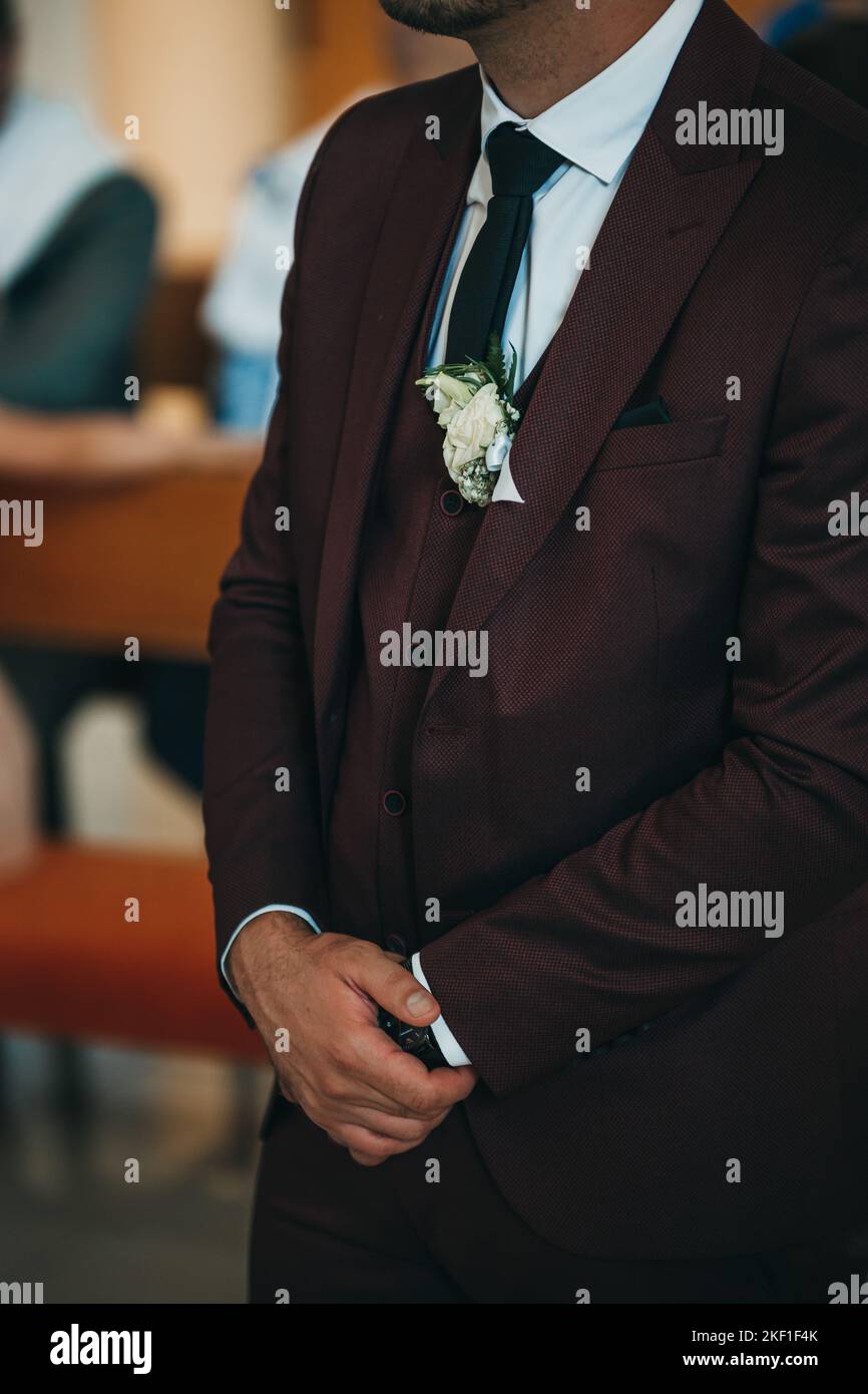 A vertical shot of a groom wearing a fancy tux during the wedding ...