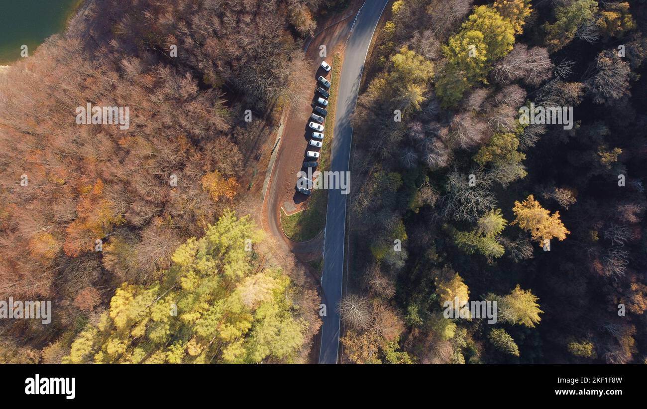 An aerial view of cars parked near the road surrounded by trees Stock ...