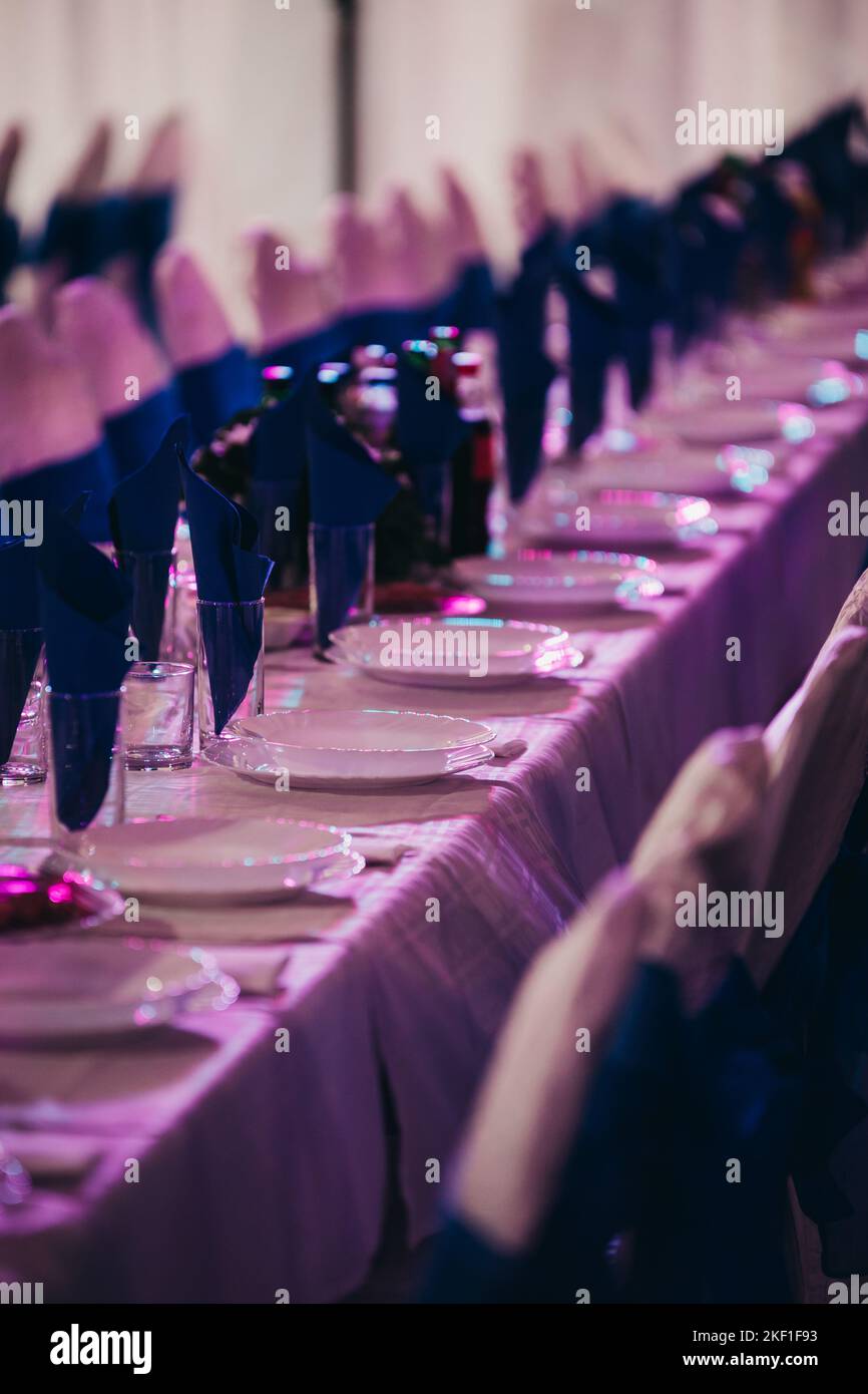 A vertical shot of a long table with beautiful decorations prepared for ...
