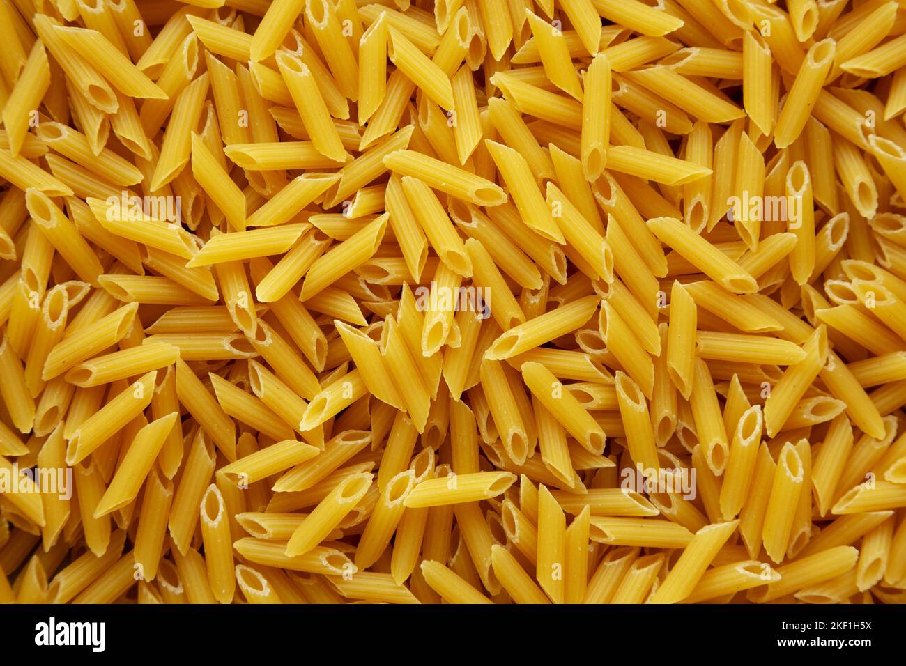 Homemade Raw Dry Mini Penne Pasta background Stock Photo - Alamy