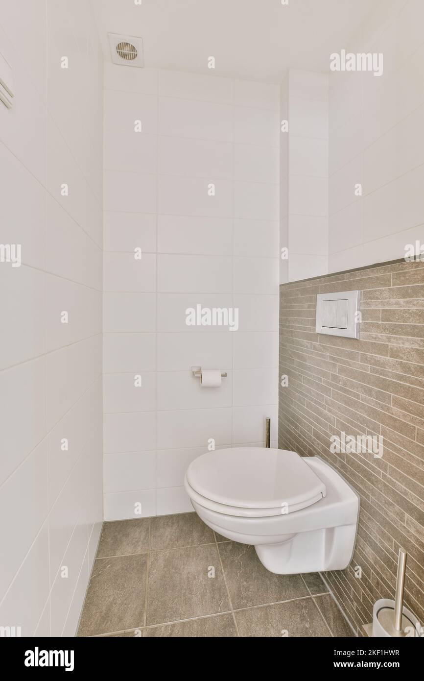 Interior of narrow restroom with wall hung toilet with white walls and ...
