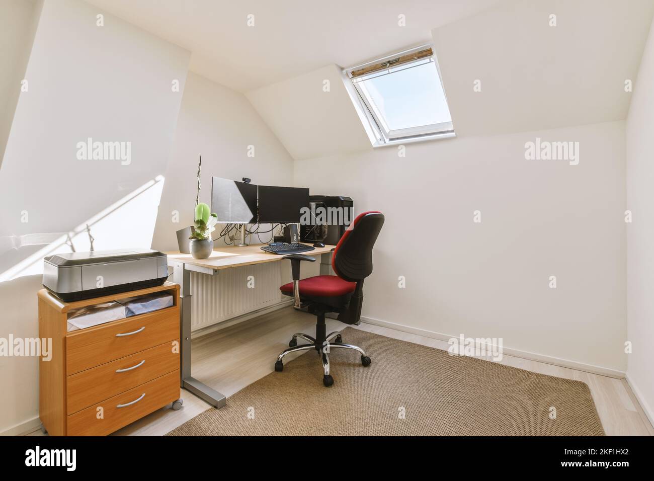Comfortable chair placed near desk with computer monitors and ...