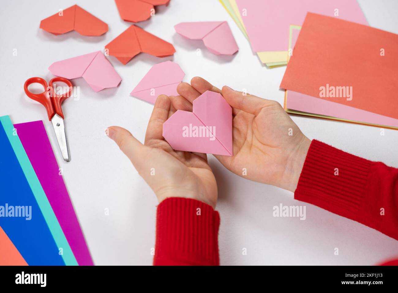 Making origami hearts for Valentine's Day. Crafts made of paper with ...