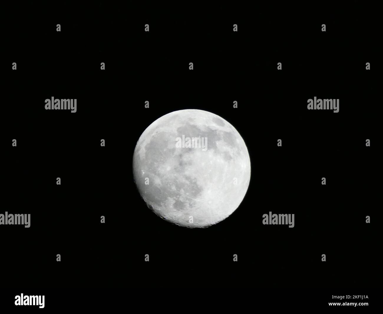 A grayscale of a lunar eclipse with moon shadows on the dark background ...