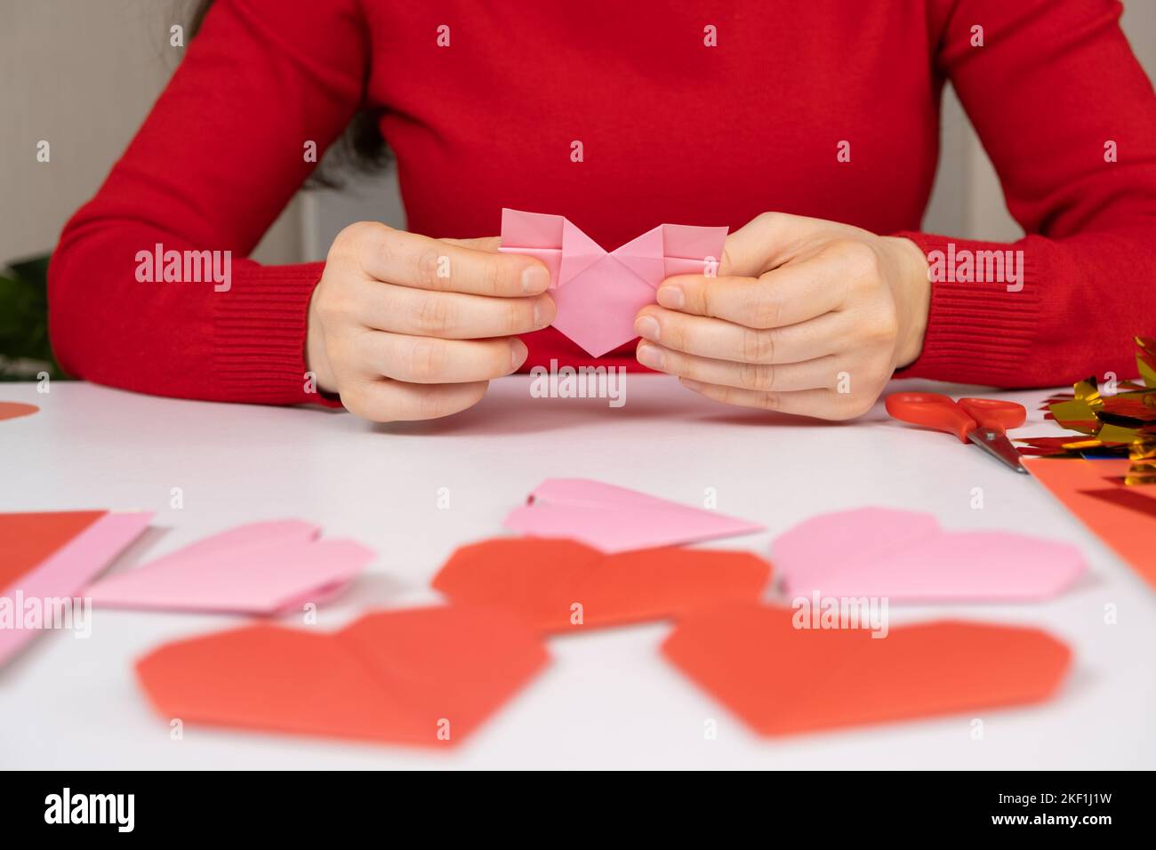 Making origami hearts for Valentine's Day. Crafts made of paper with ...