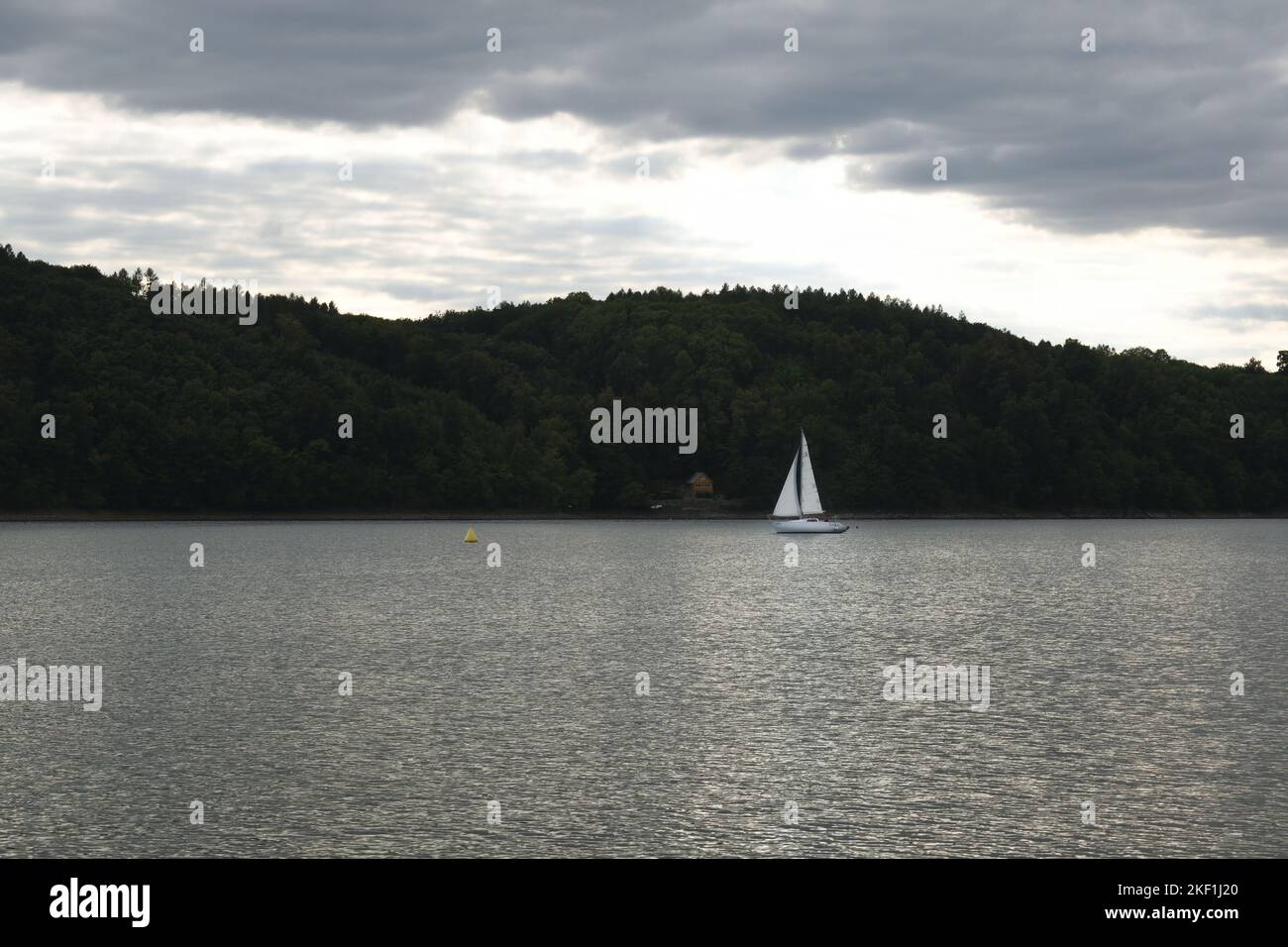 A high-angle of a boat flowing in the lake at sunset with mountain ...