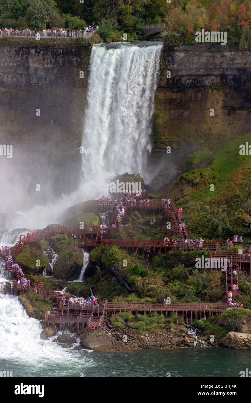 A vertical low-angle of Niagara Falls with trees and sky background ...