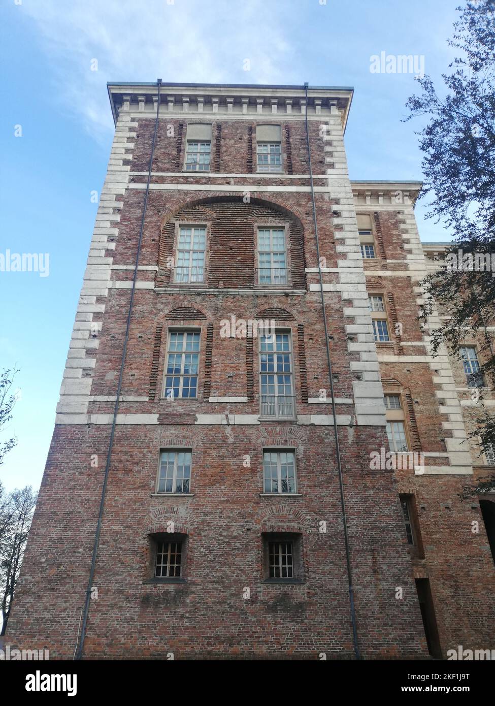 A vertical undershot of the castle of Rivoli against a cloudy, sunlit ...