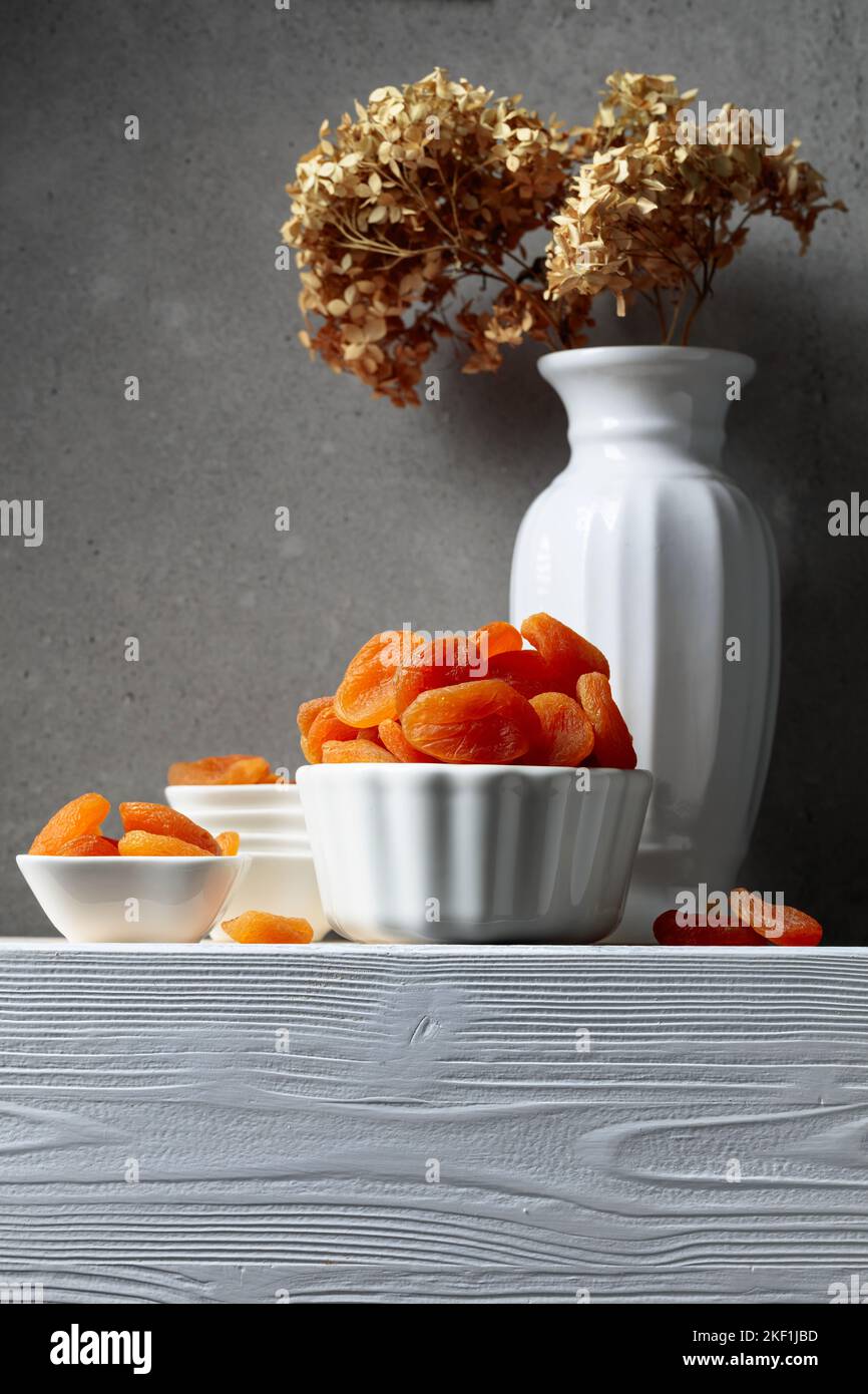 Dried apricots on a white wooden table. Copy space Stock Photo - Alamy