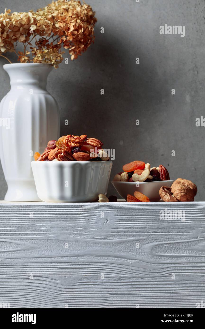 Dried fruits and nuts on a white wooden table. Copy space Stock Photo ...