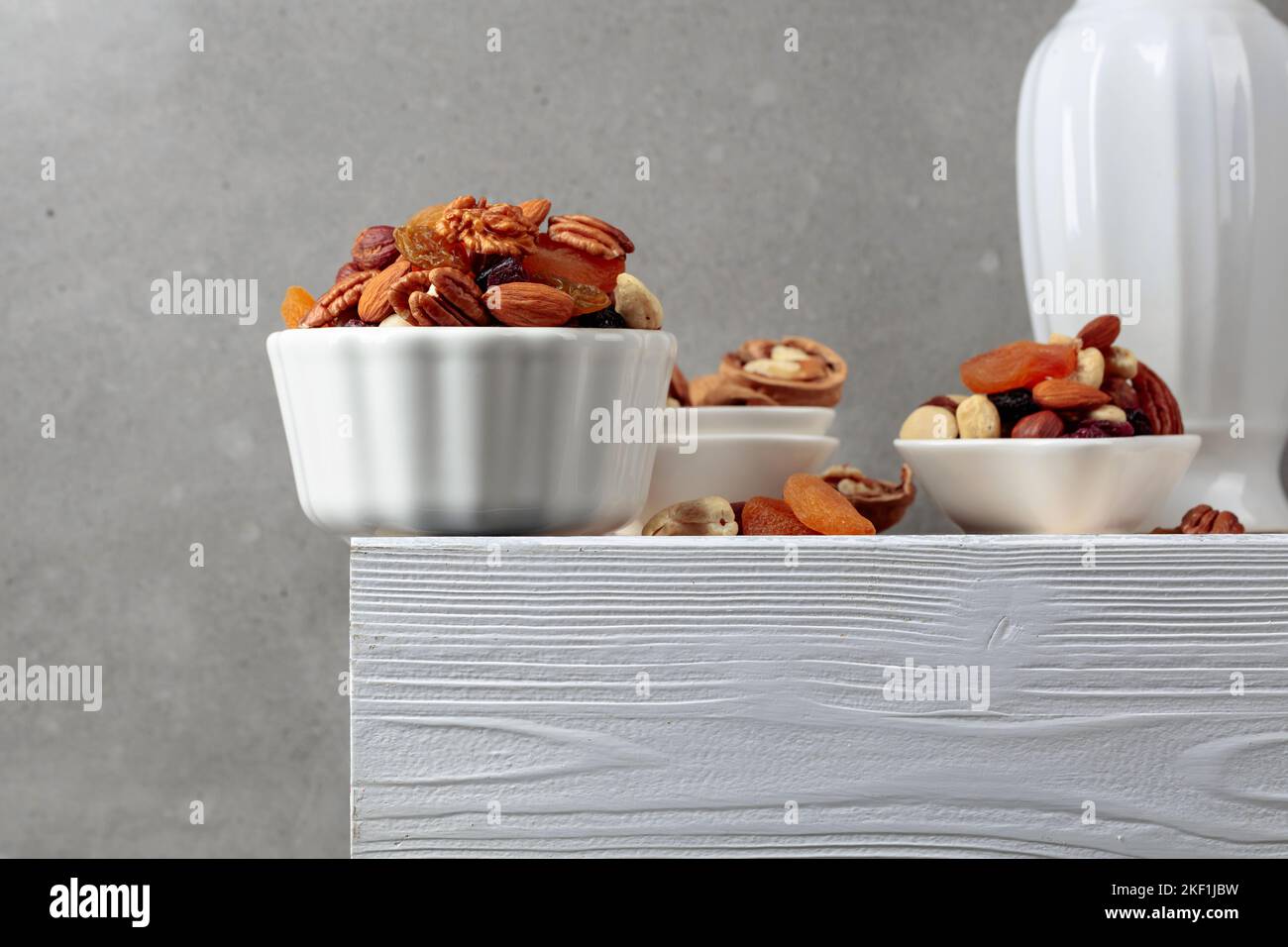 Dried fruits and nuts on a white wooden table. Copy space Stock Photo ...