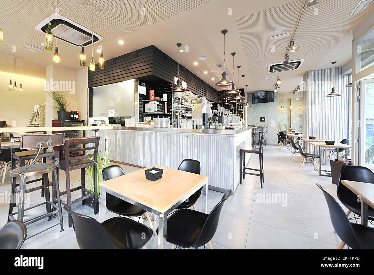 Lounge of a coffee shop with wooden tables and polished metal bar ...