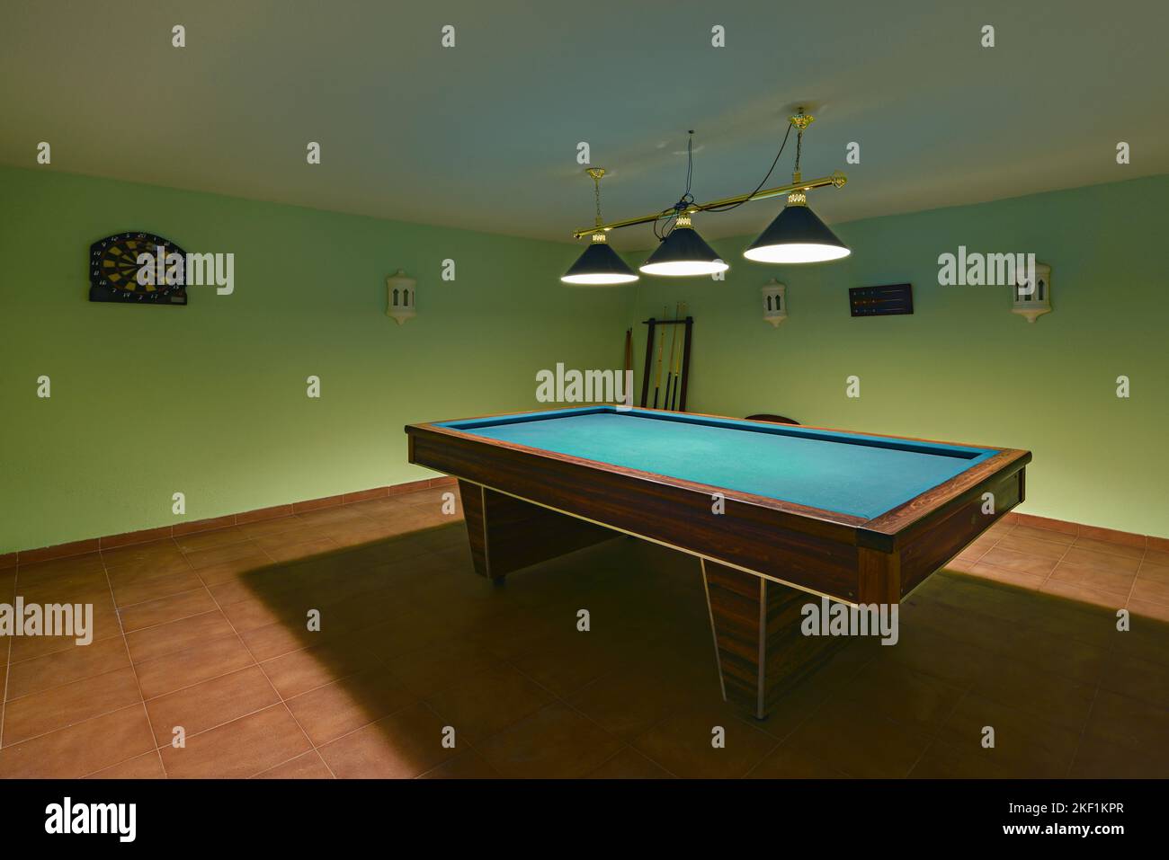 Wooden pool table in a room with green painted walls and brown ...