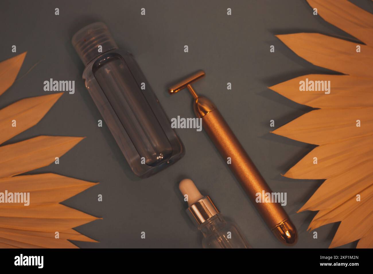 Vibrating golden facial massager, glass jar with oil dropper for ...