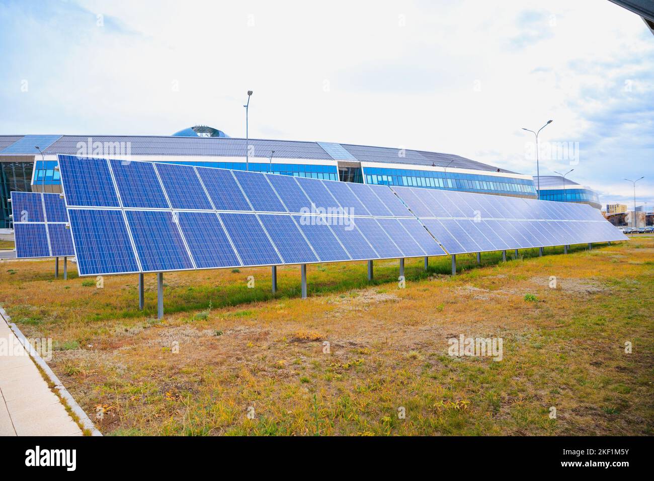 Rows of solar power panels on lawn in big city. Concept for using clean ...