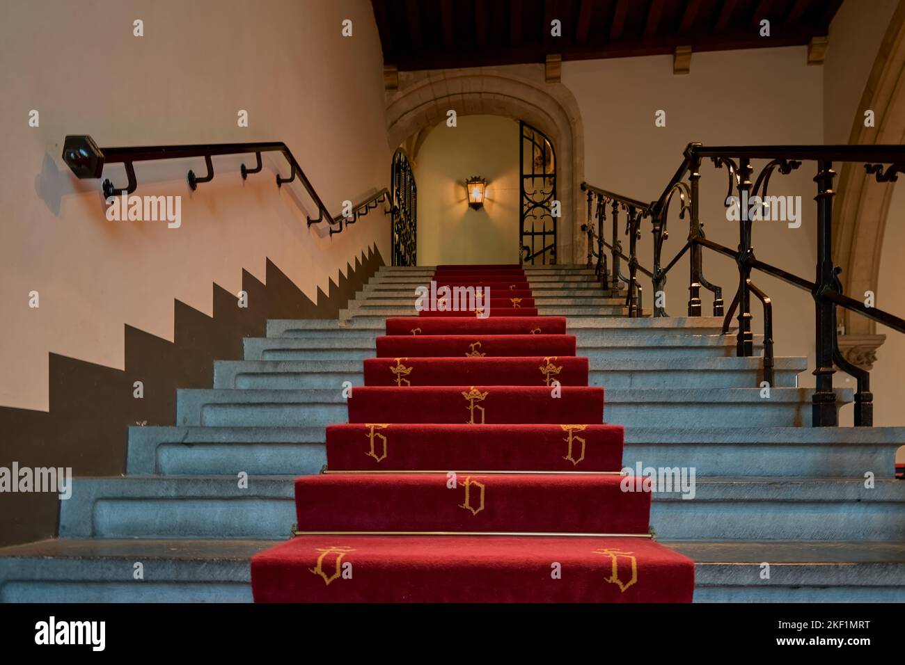 The gothic staircase with red carpet and wrought iron railings of the ...