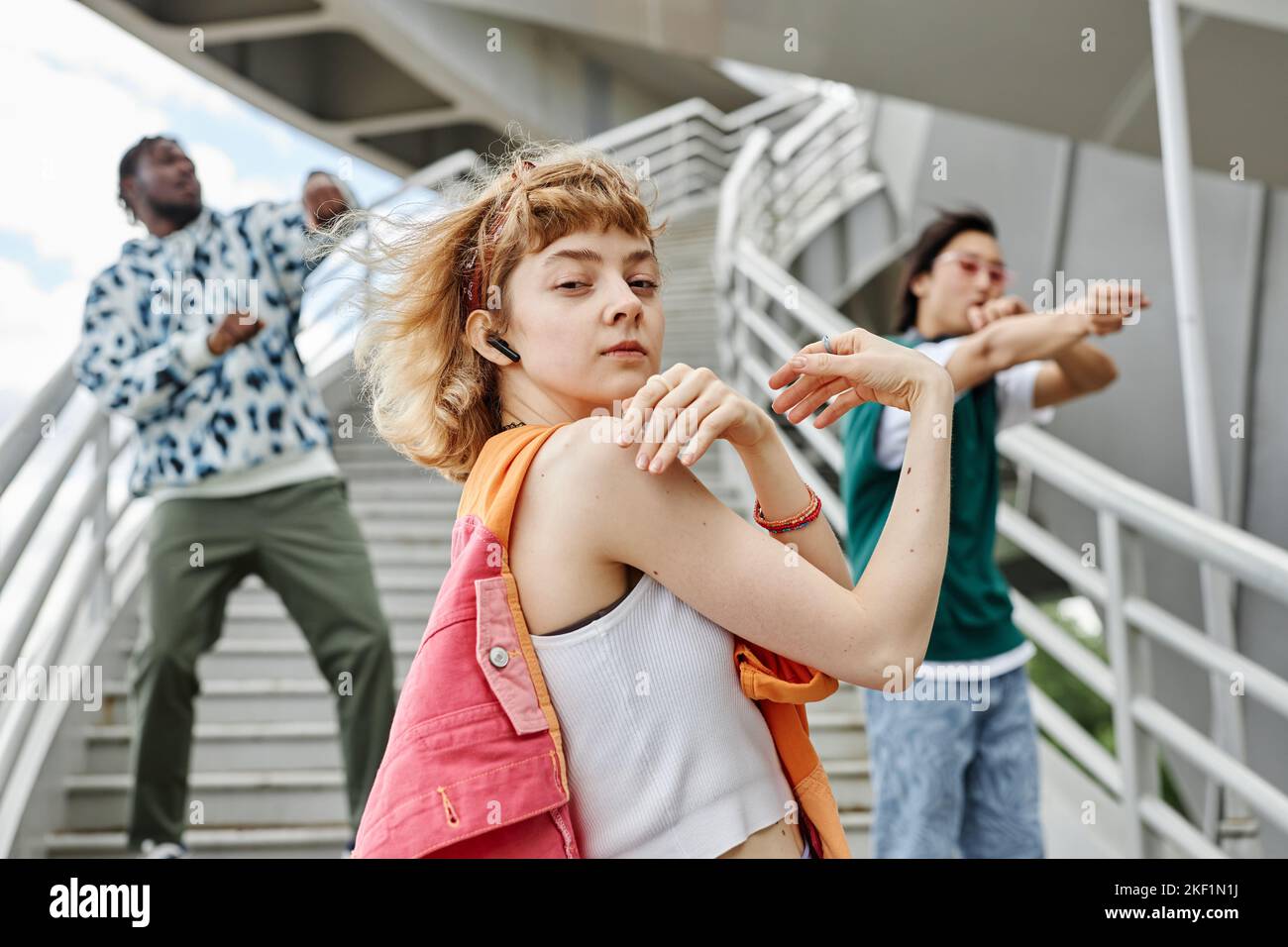 Diverse group of people wearing colorful clothes dancing outdoors in ...