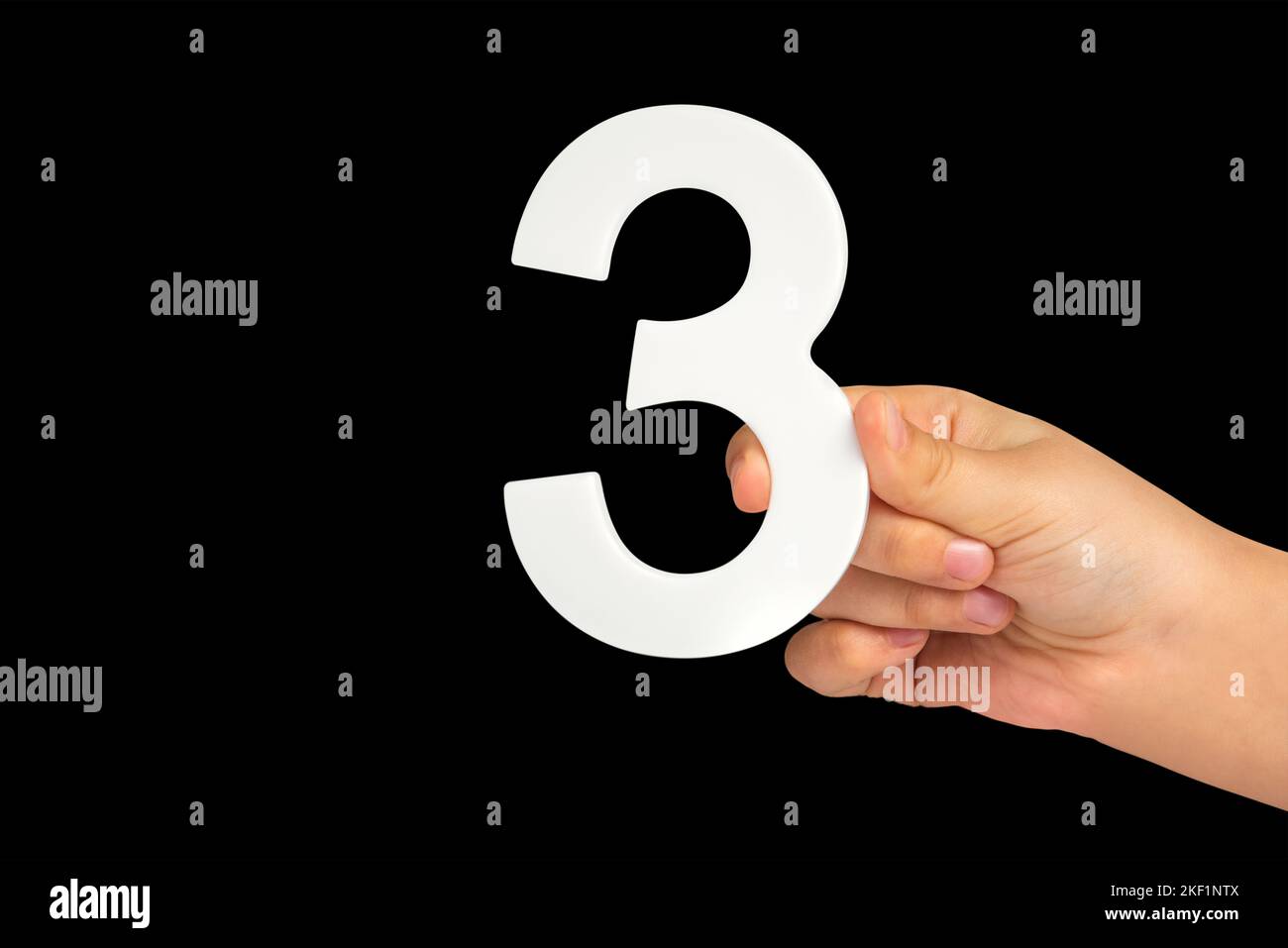 number three in hand isolated on black background. Number three in a ...