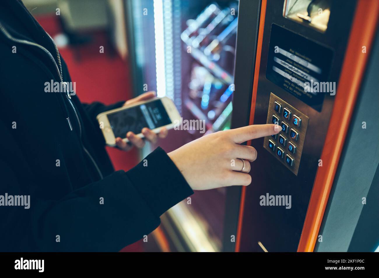 Woman paying for product at vending machine using contactless method of ...
