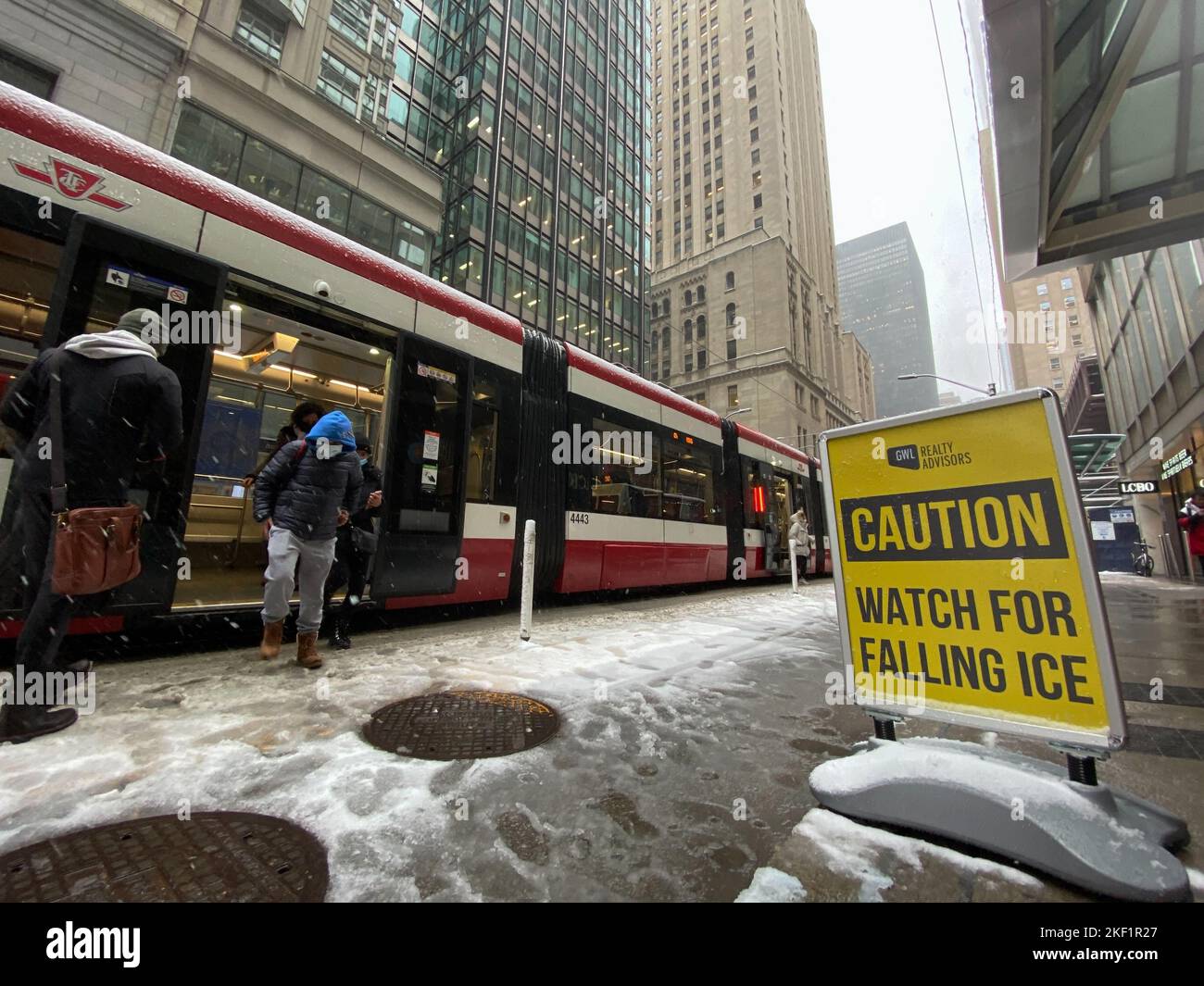 Passengers step off a streetcar during a snowy day in Toronto on ...