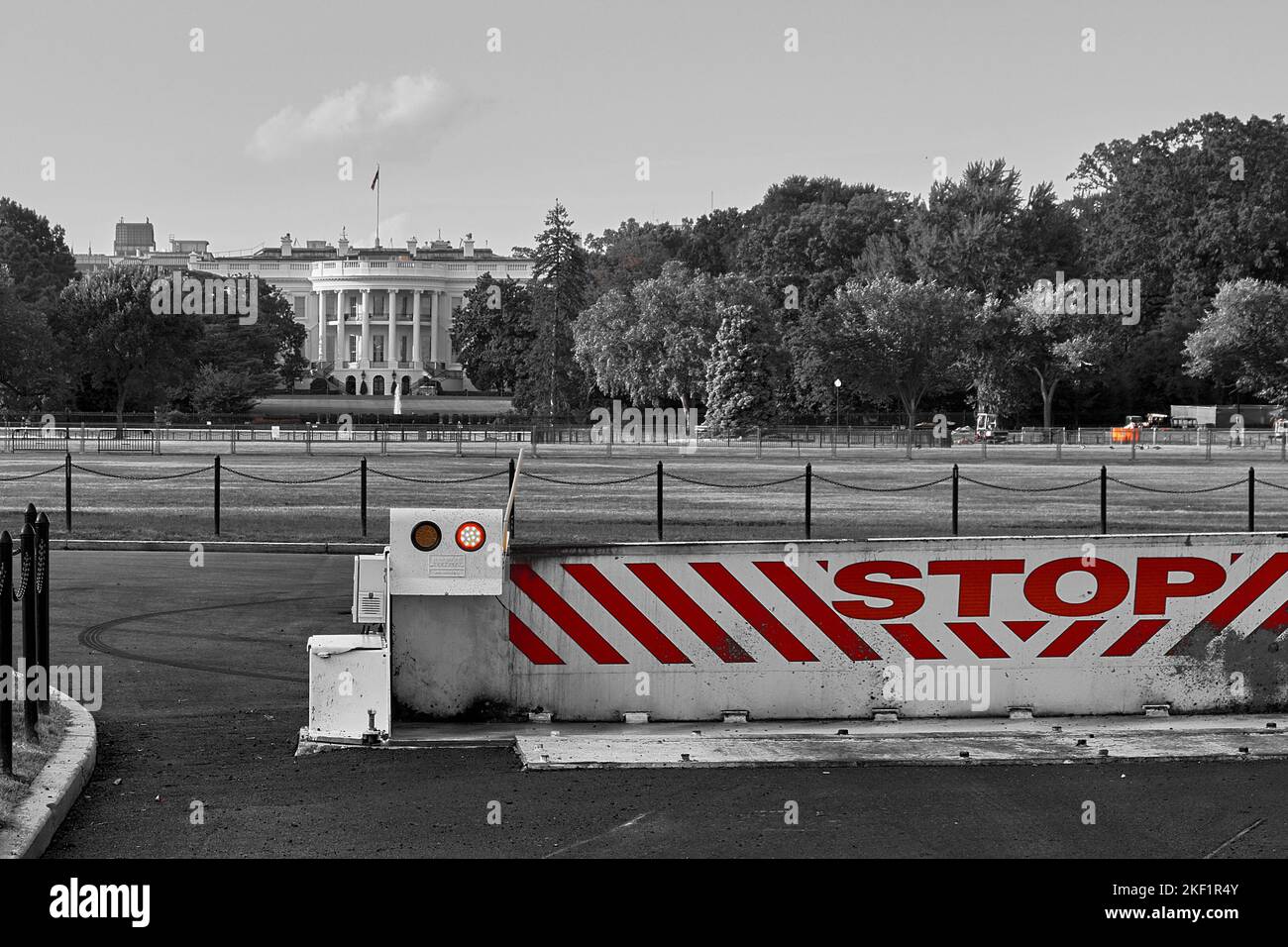 Close-up of a barrier with a red stop sign and the white house in the ...
