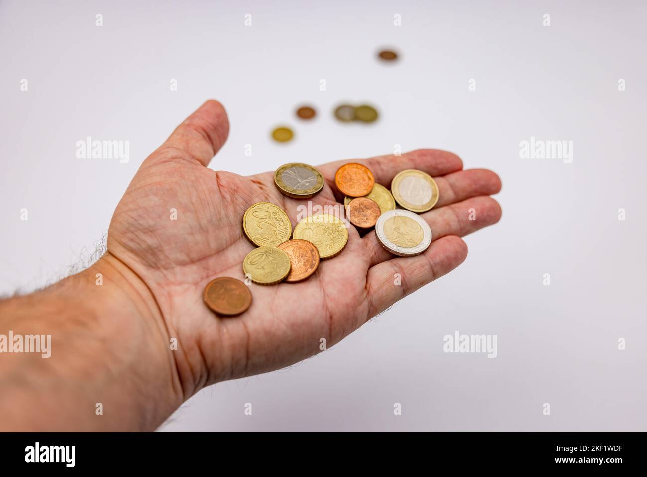 Little cash and money in euro coins in hand against white background ...