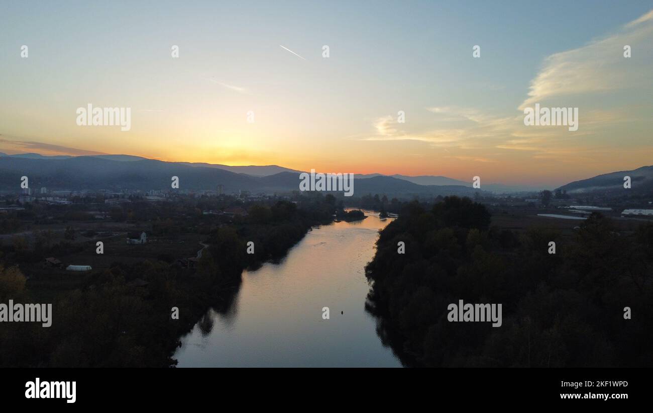 An aerial view of a deep river surrounded with dense forests on the ...