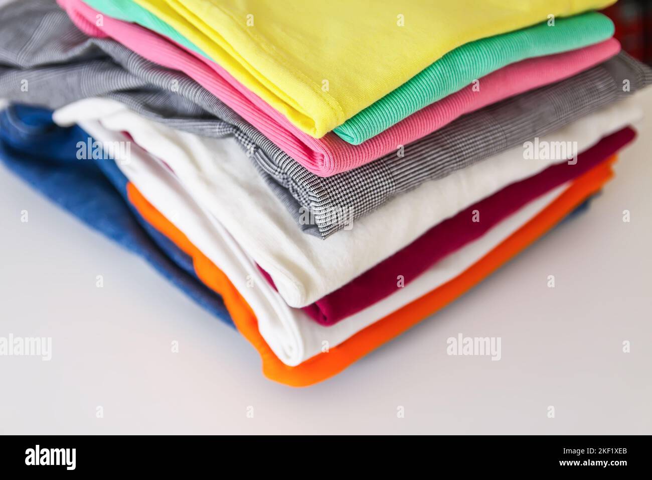 Stack of folded colorful clothes. Compact storage organizing in home ...
