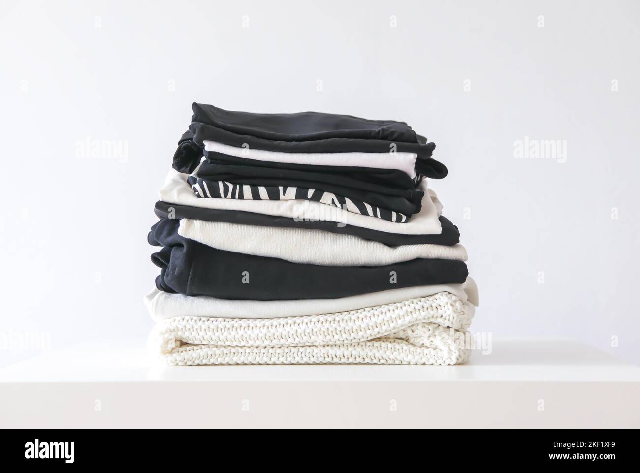 Stack of folded colorful clothes. Compact storage organizing in home ...