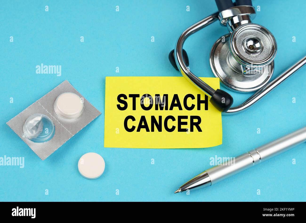 Medical concept. On a blue surface, a stethoscope, pills, a pen and a ...