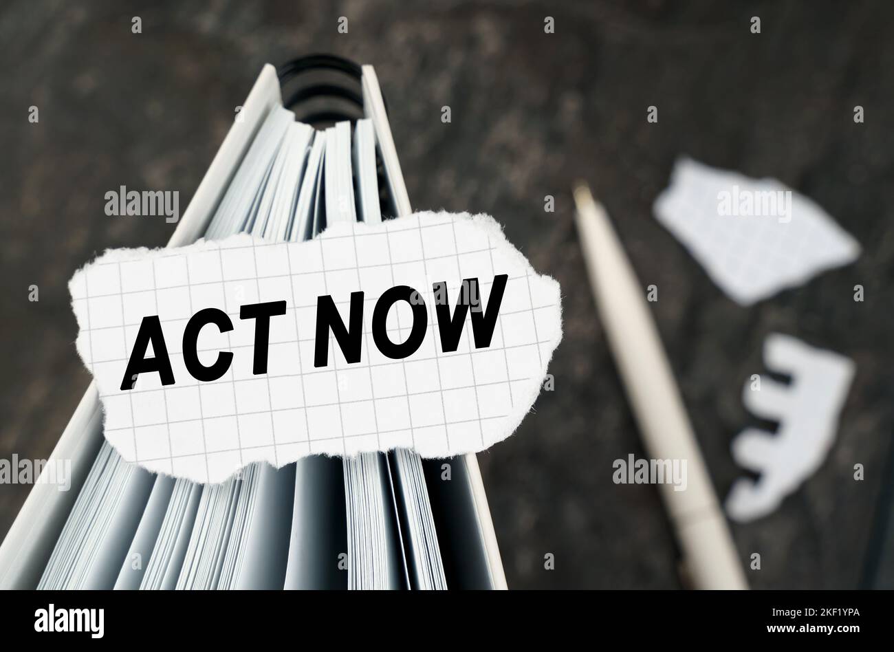 On the table is a notebook on which lies a piece of torn paper with the ...