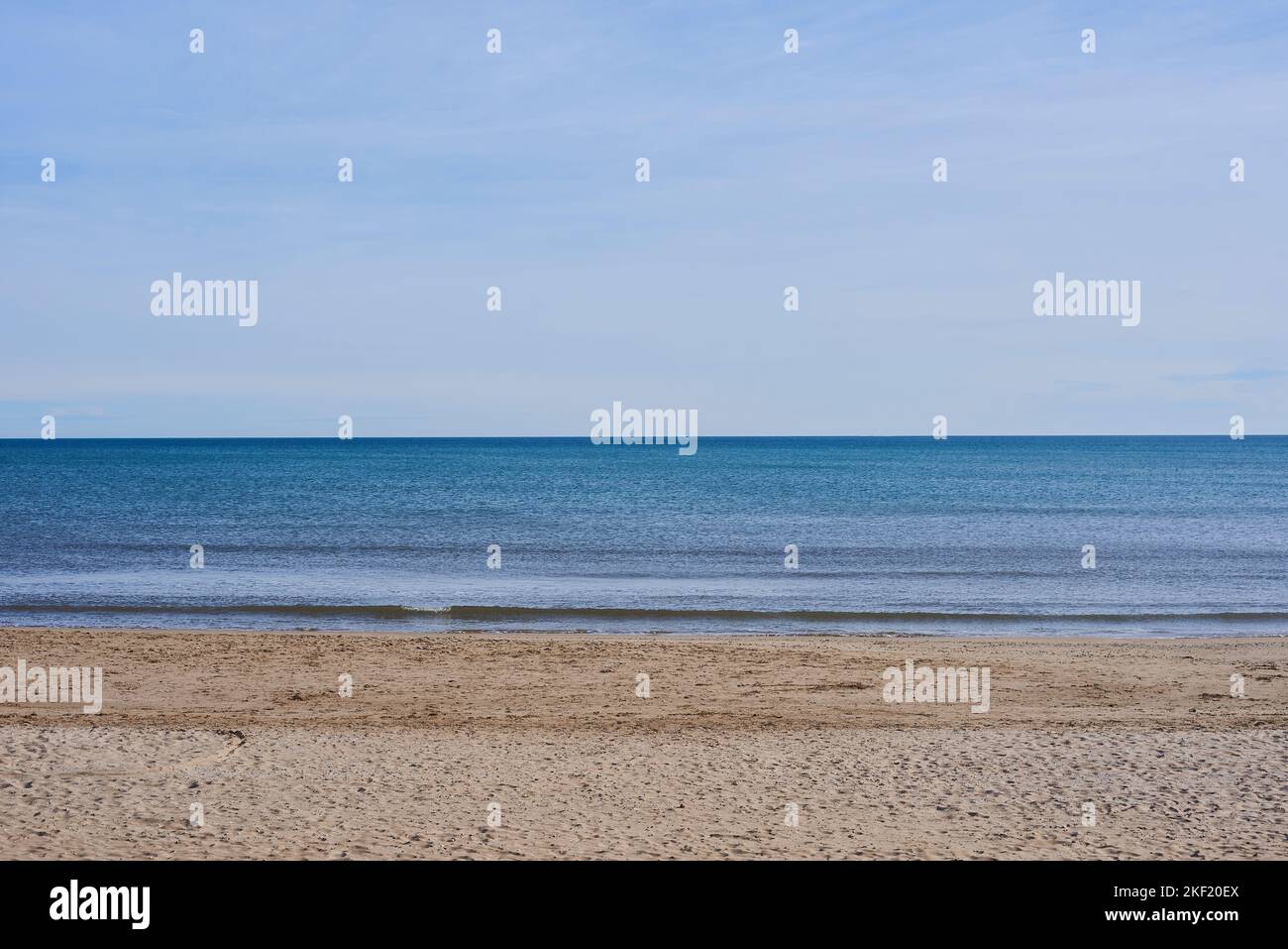 A lonely beach, blue sky, empty space. Horizontal, parallel, calm water ...