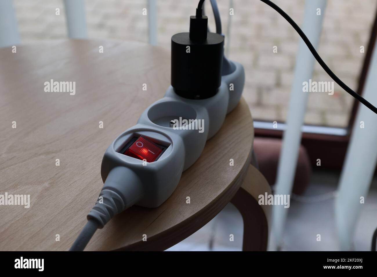 A portrait of a white power strip with a red on off button with a black ...